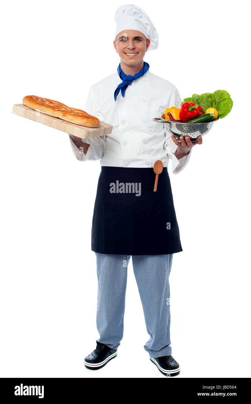 Experienced male chef holding bread and vegetables Stock Photo - Alamy