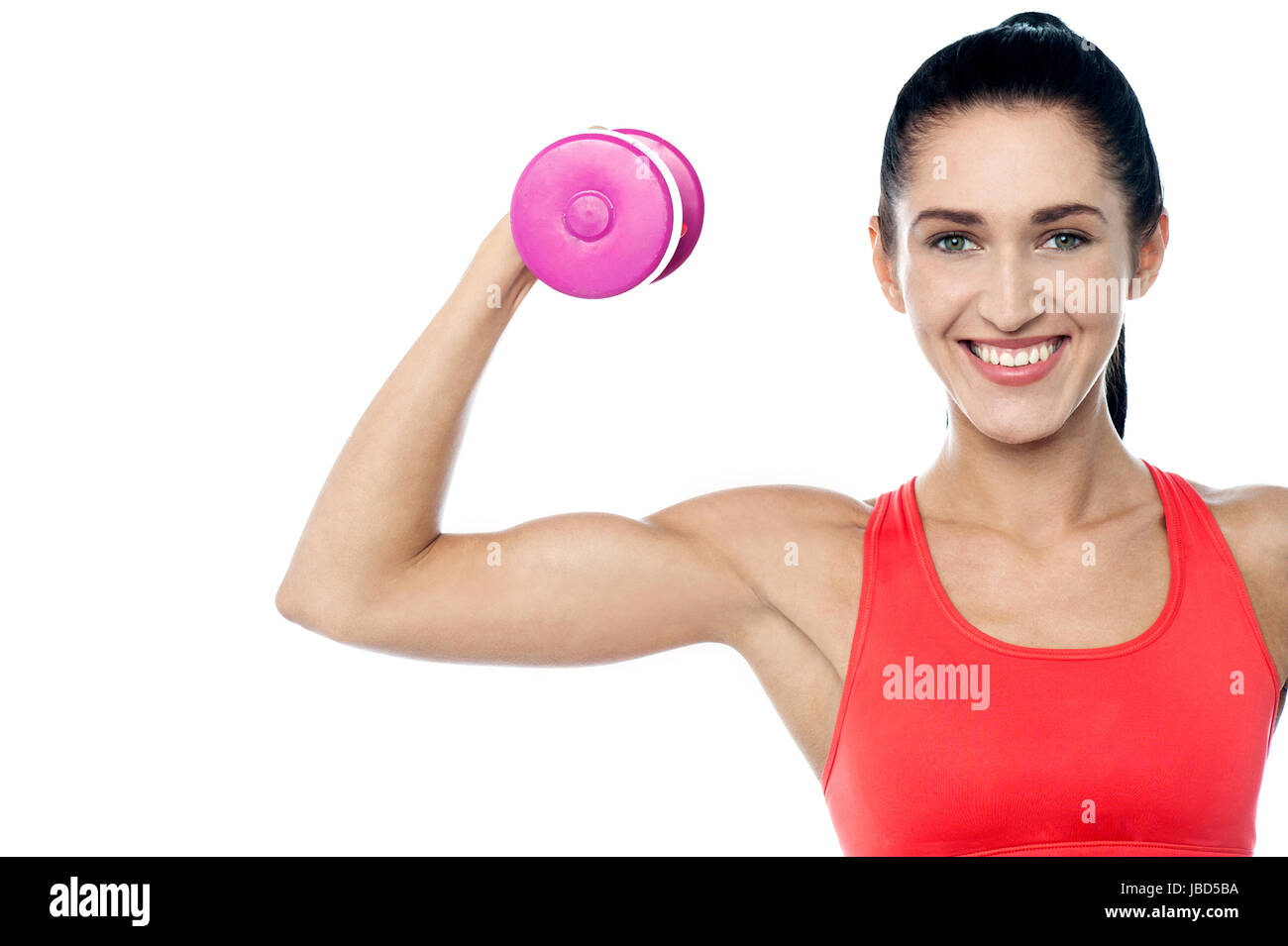 Smiling young fitness woman lifting pink dumbbell Stock Photo - Alamy