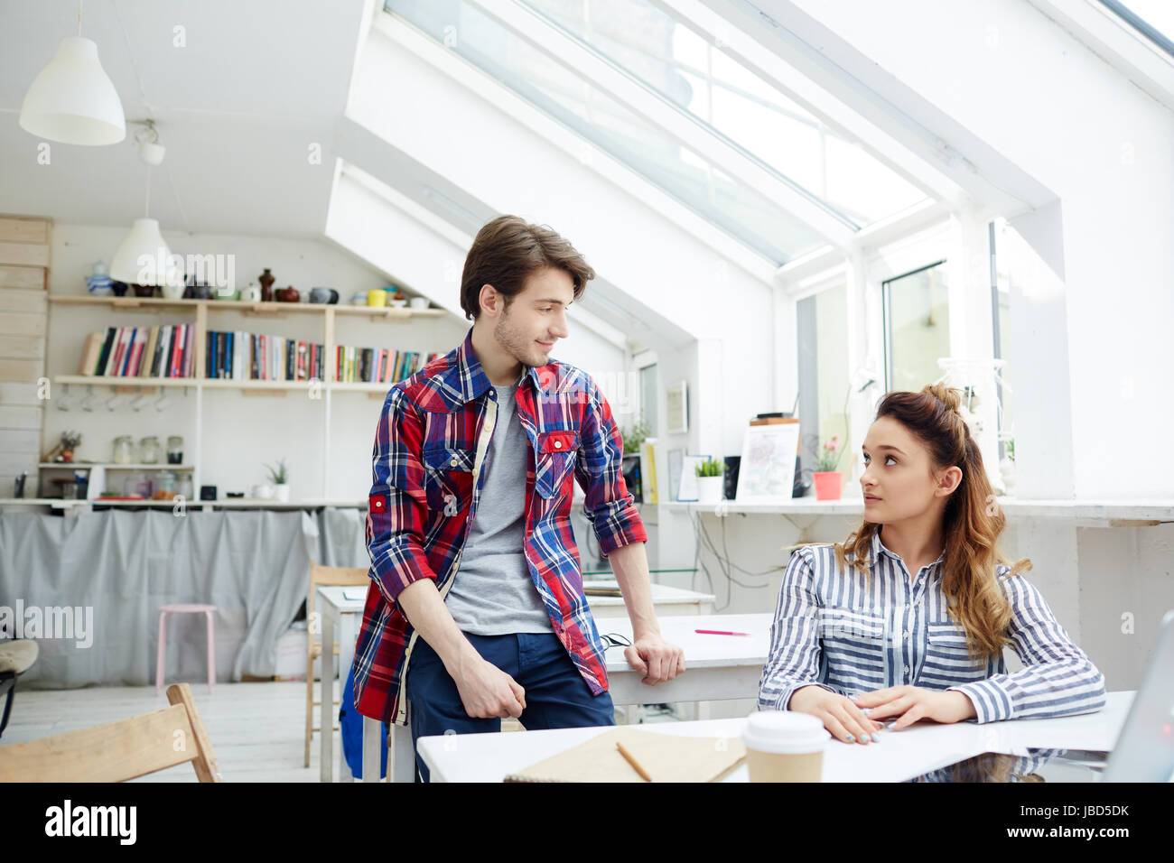 Friendly guy and girl having talk in classroom Stock Photo - Alamy