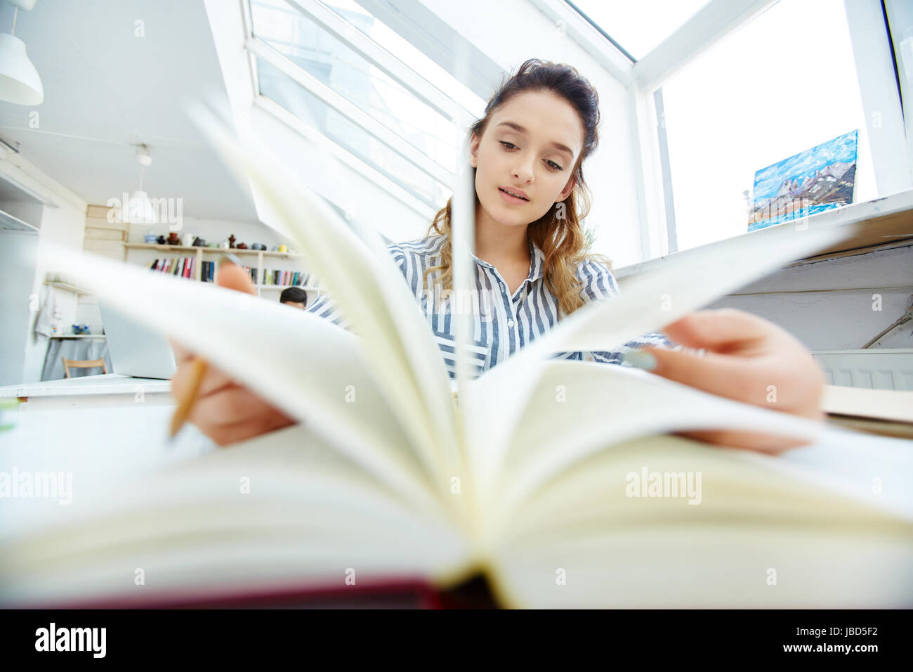 Curious teenager looking through interesting book Stock Photo - Alamy