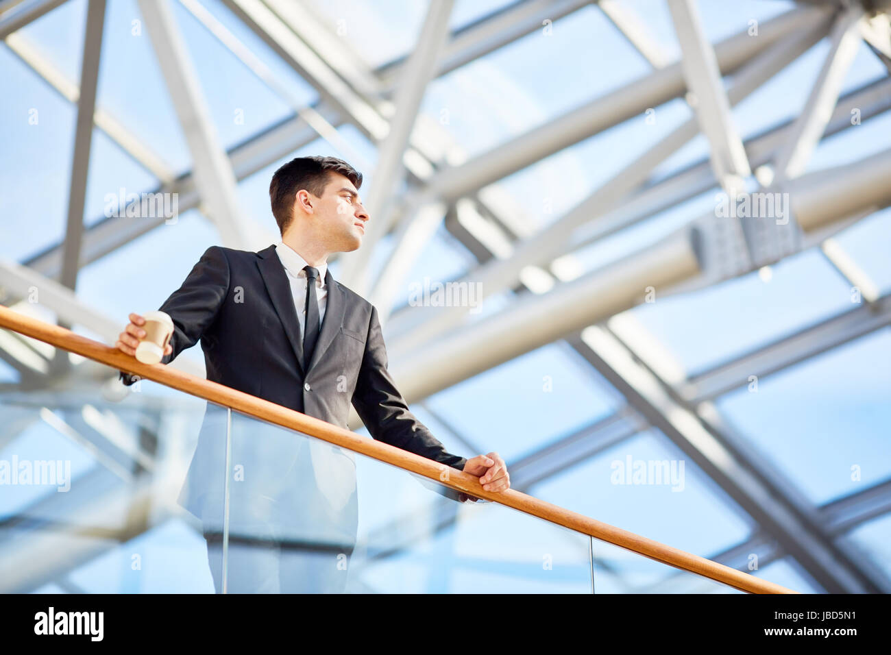 Restful businessman with drink having break Stock Photo - Alamy