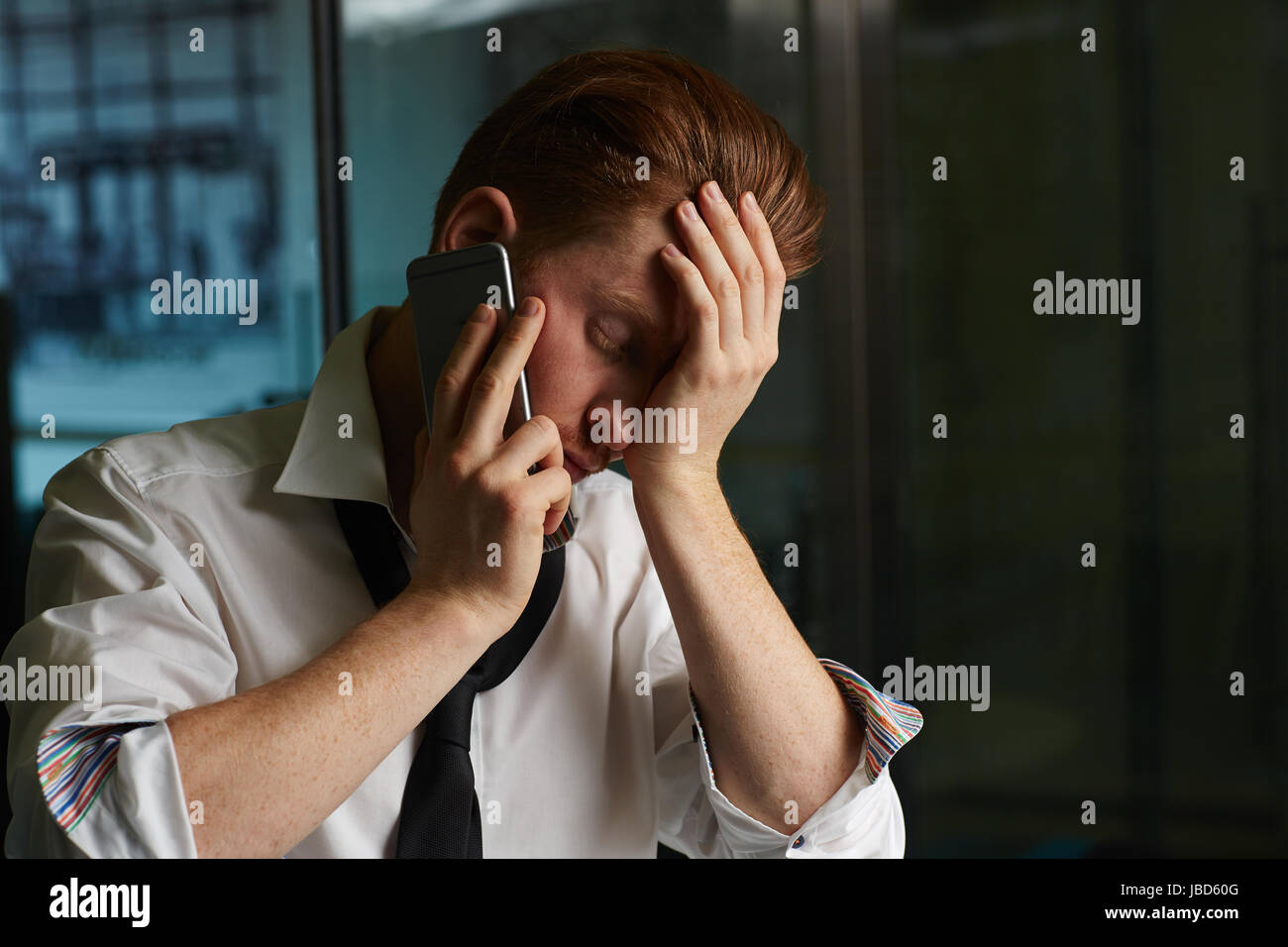 Overworked man talking by smartphone at night Stock Photo - Alamy