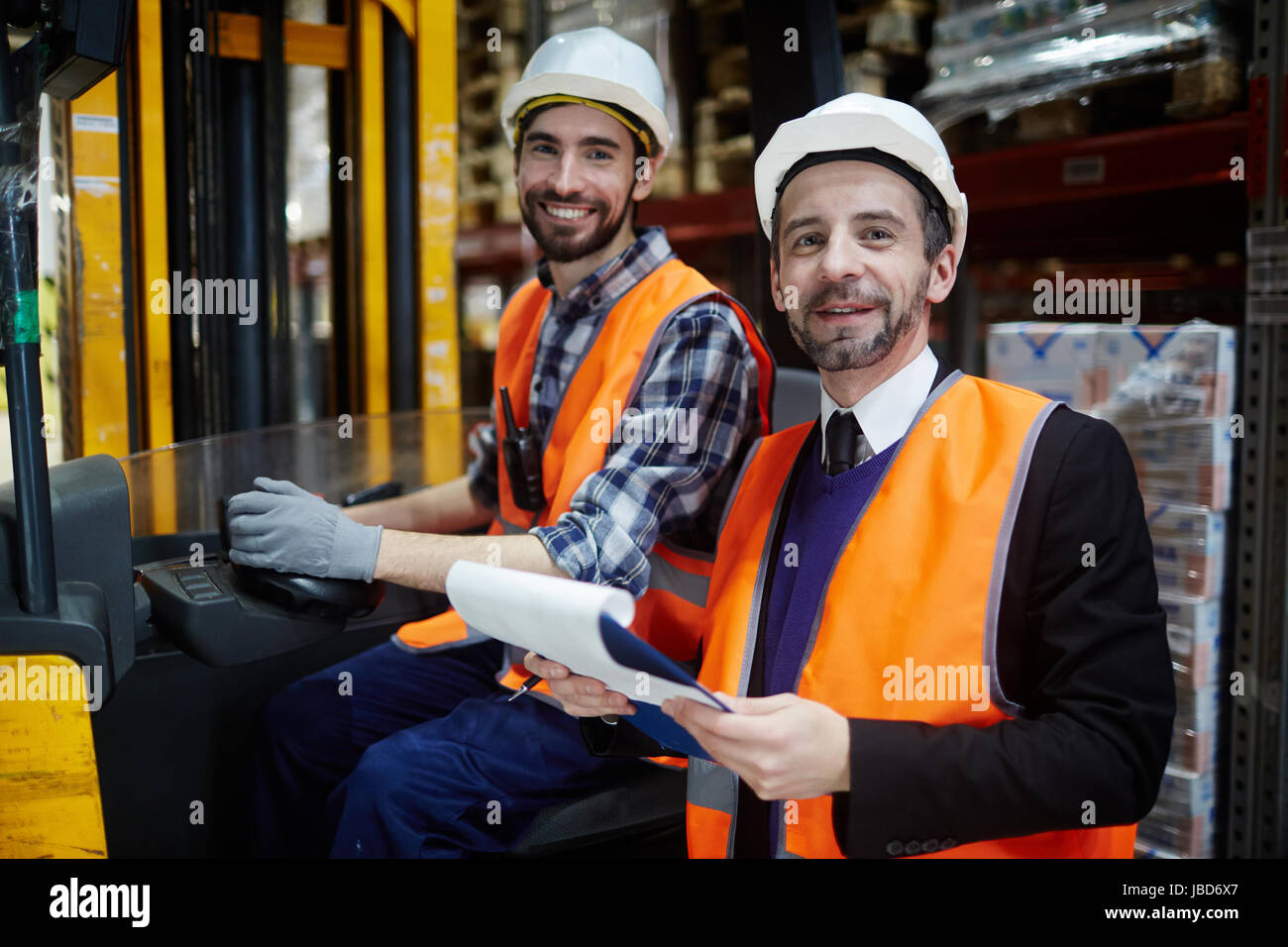 Happy men in uniform and helmets looking at camera at work Stock Photo ...