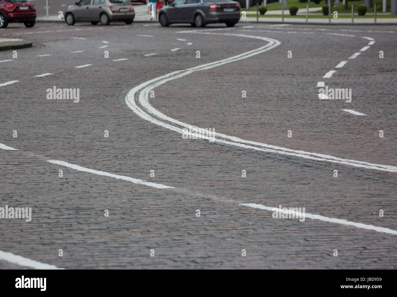 curved road made from a cobblestone stone blocks with marking in ...