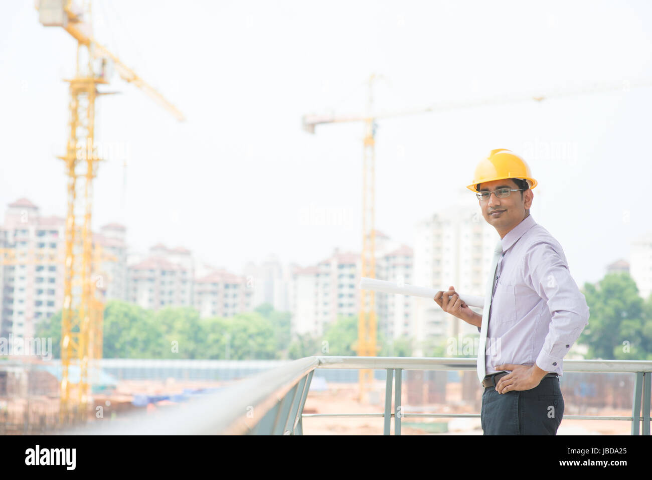 Portrait of a smiling Asian Indian male contractor engineer with hard ...