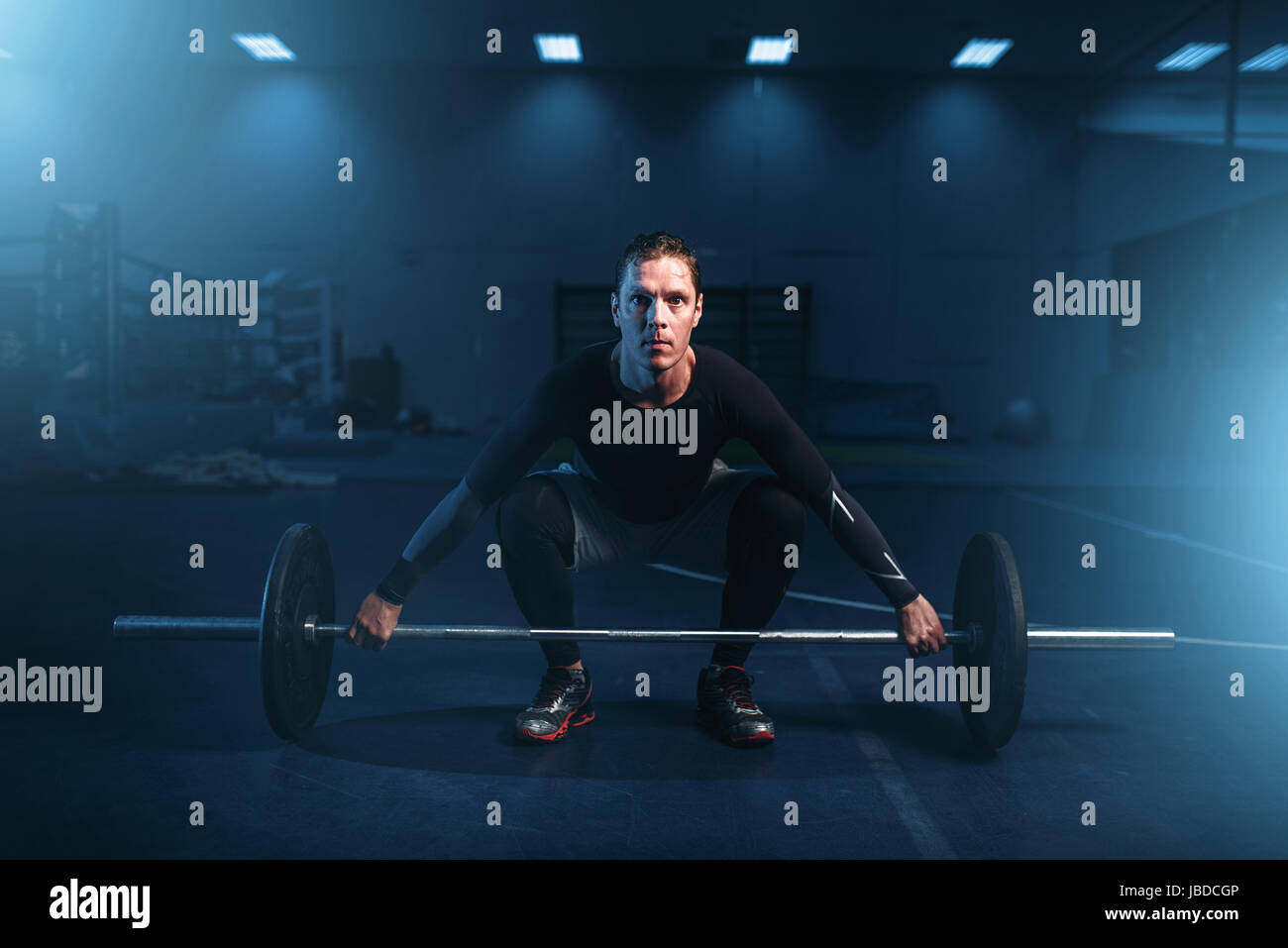 Strength athlete on training, workout with barbell in gym. Active sport ...