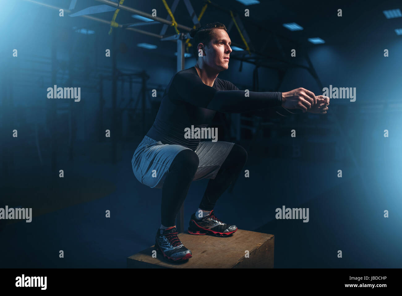 Athlete on training, endurance exercise with box in gym. Energy workout ...