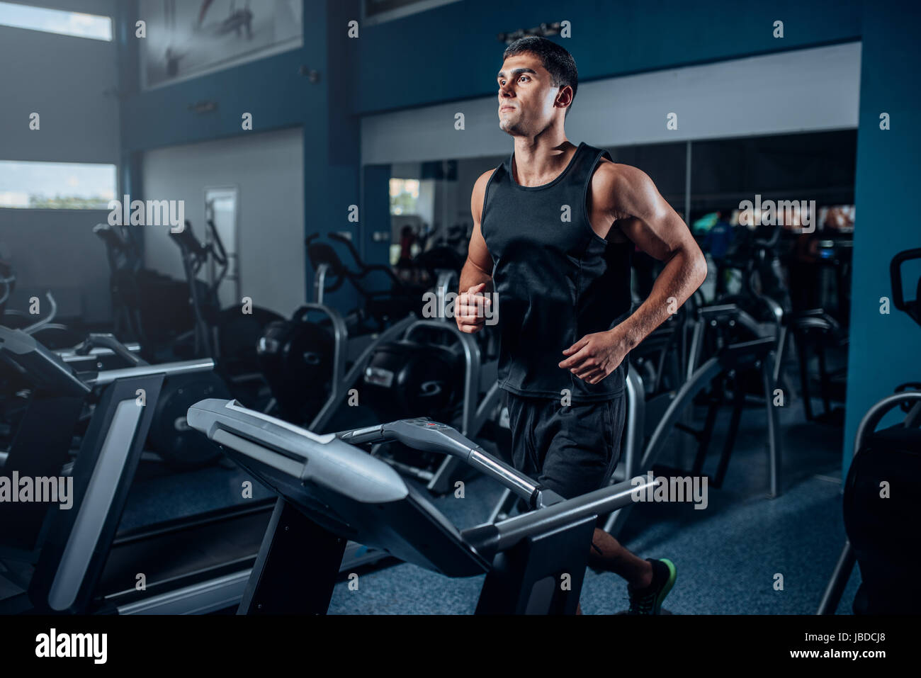 Male athlete workout on running exercise machine. Active sport training ...