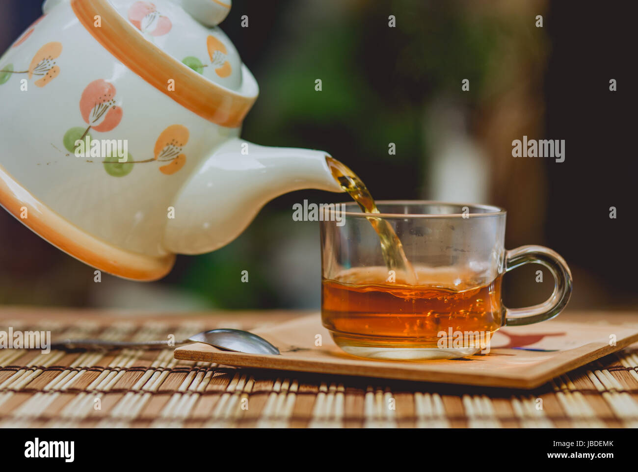 Pouring tea with teapot on wooden table , breaking time Stock Photo - Alamy