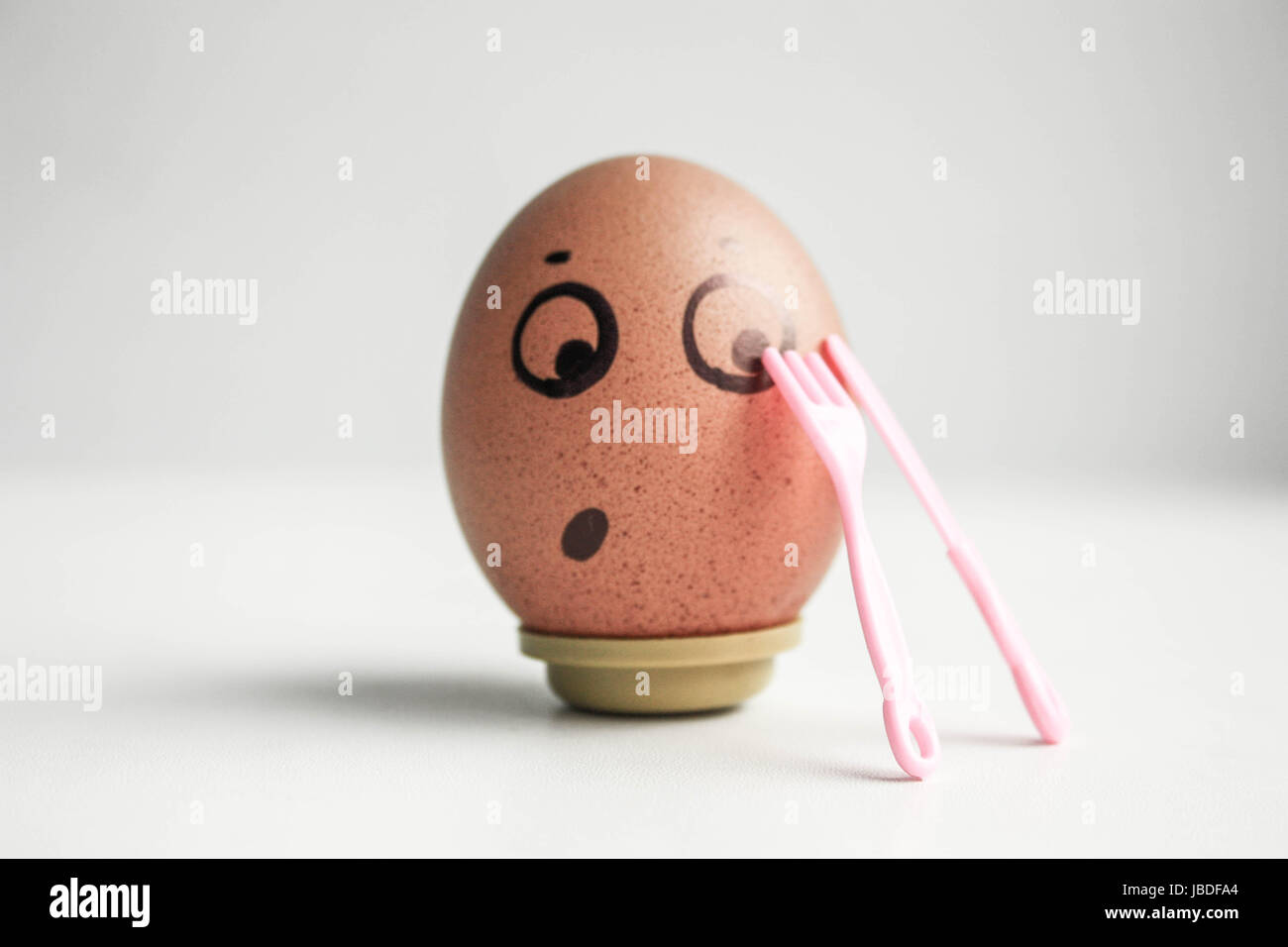 Danger of sharp objects and eyes. An egg with a painted face. Cute egg ...