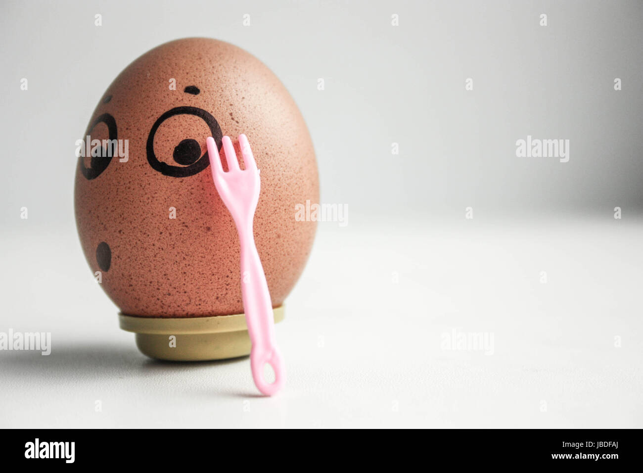 Danger of sharp objects and eyes. An egg with a painted face. Cute egg ...