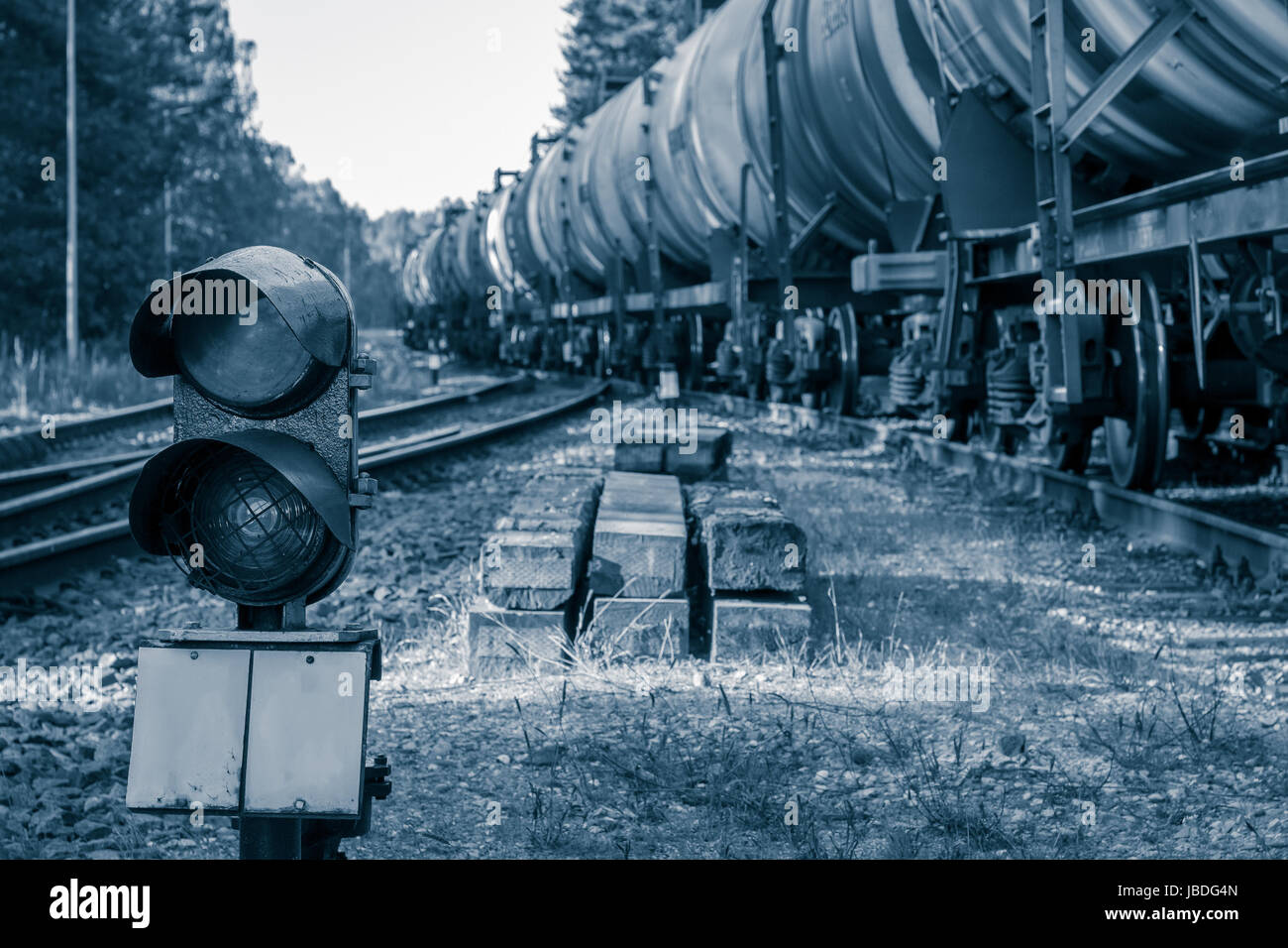 Railroad traffic light and freight train on behind Stock Photo - Alamy