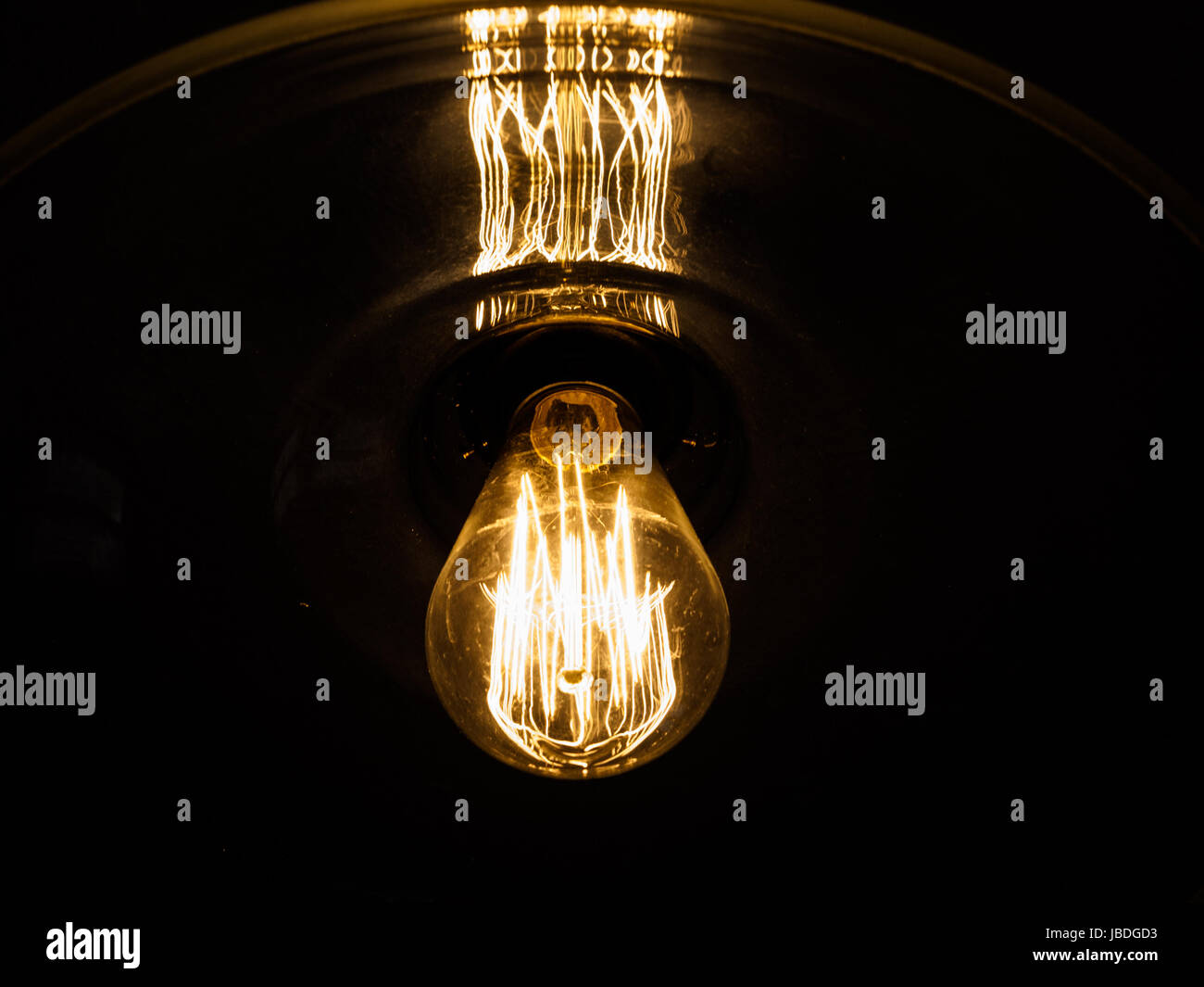 An old fashioned lightbulb illuminates in the darkness Stock Photo - Alamy