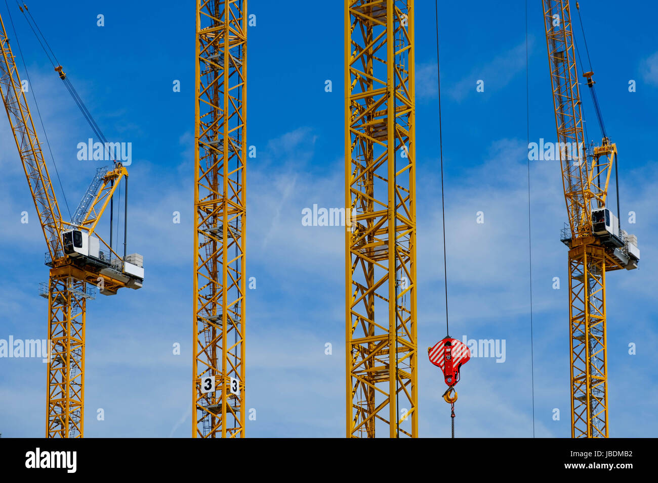 many yellow construction cranes on blue sky backgrounds Stock Photo - Alamy