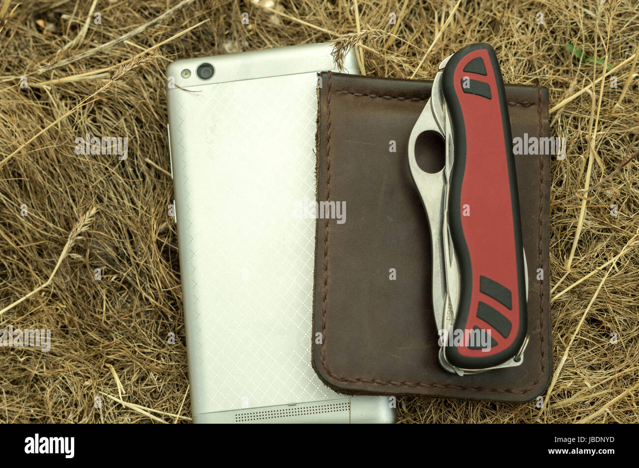 Mobile phone and knife in the manger. Multi-functional knife. Wallet ...
