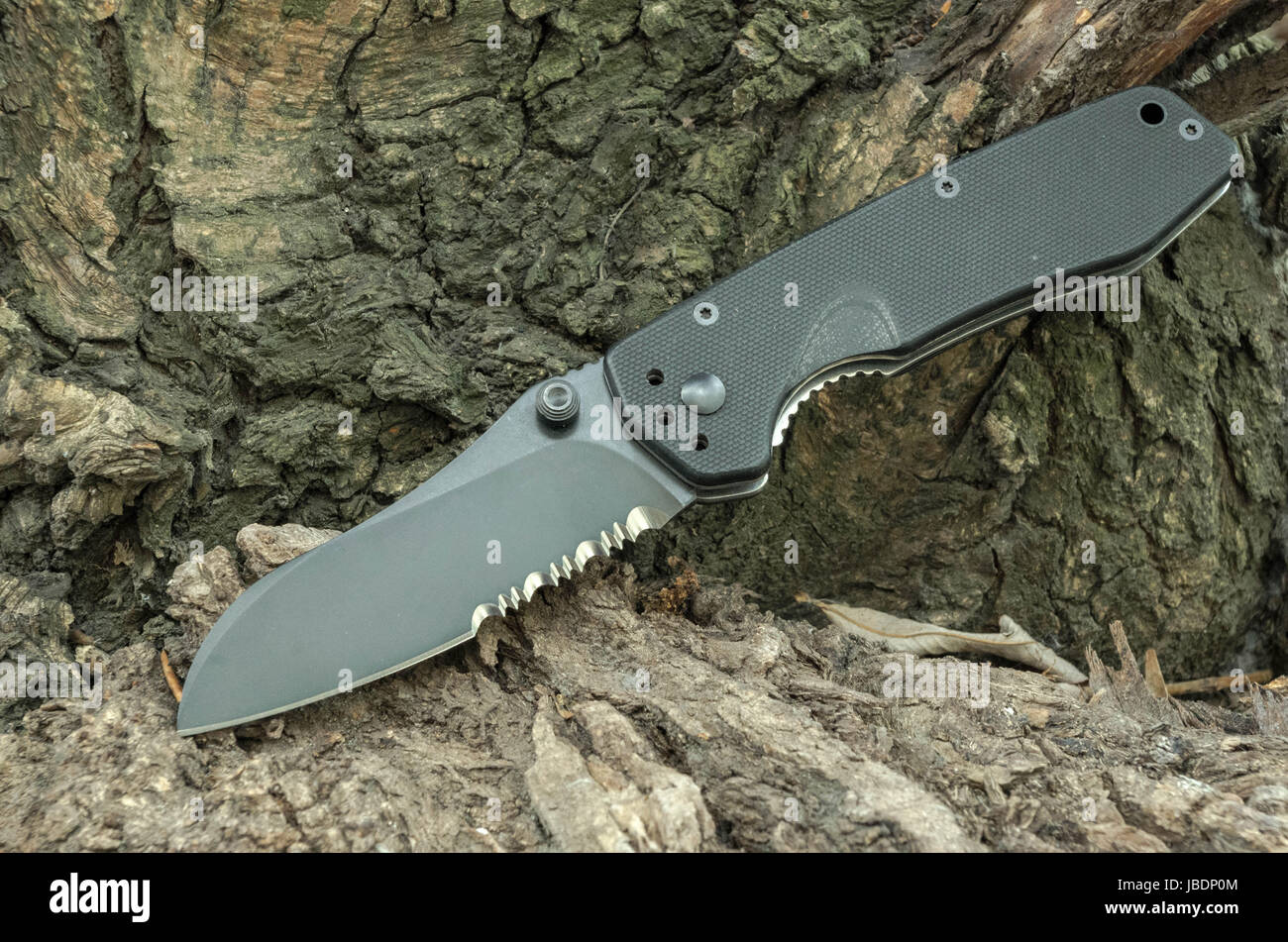 Black knife on a tree bark. Pocket knife. Tourist knife Stock Photo - Alamy