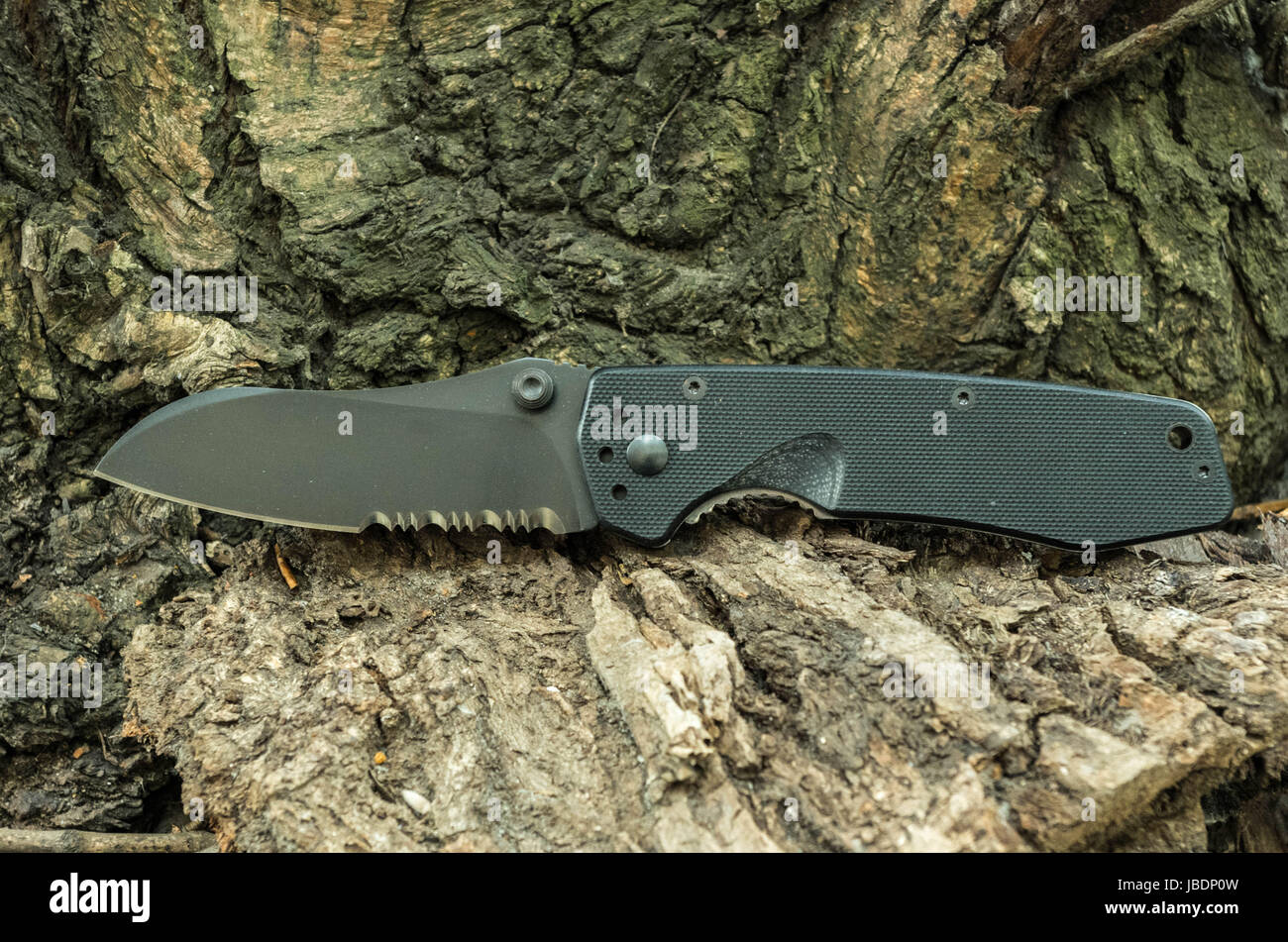 Black knife. Pocket knife. A knife with a serration blade Stock Photo ...