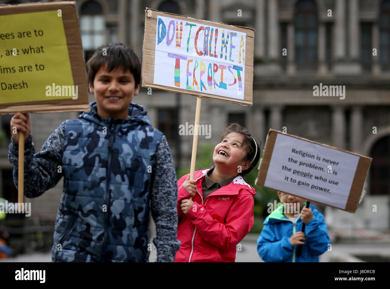 Fatima Akbar, aged 8 (centre) carries a sign she made at the Muslims ...