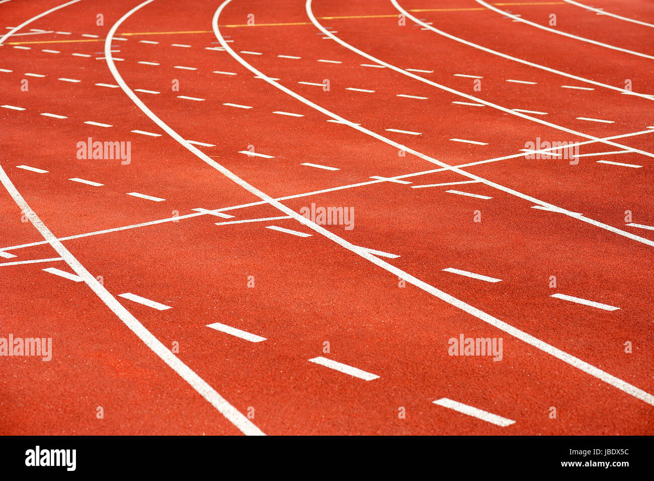 Red running track with curvy lanes Stock Photo - Alamy