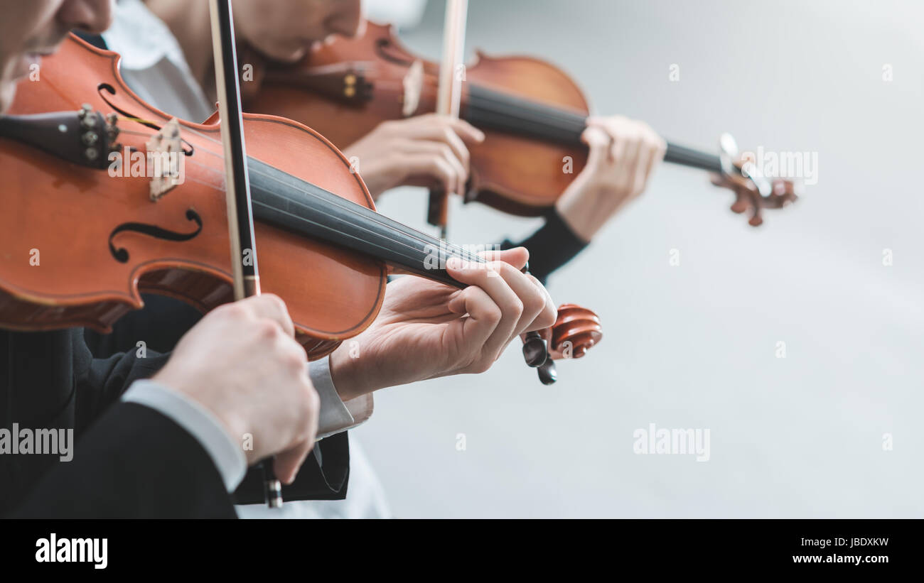 Two violinists performing together hands close up, classical music ...