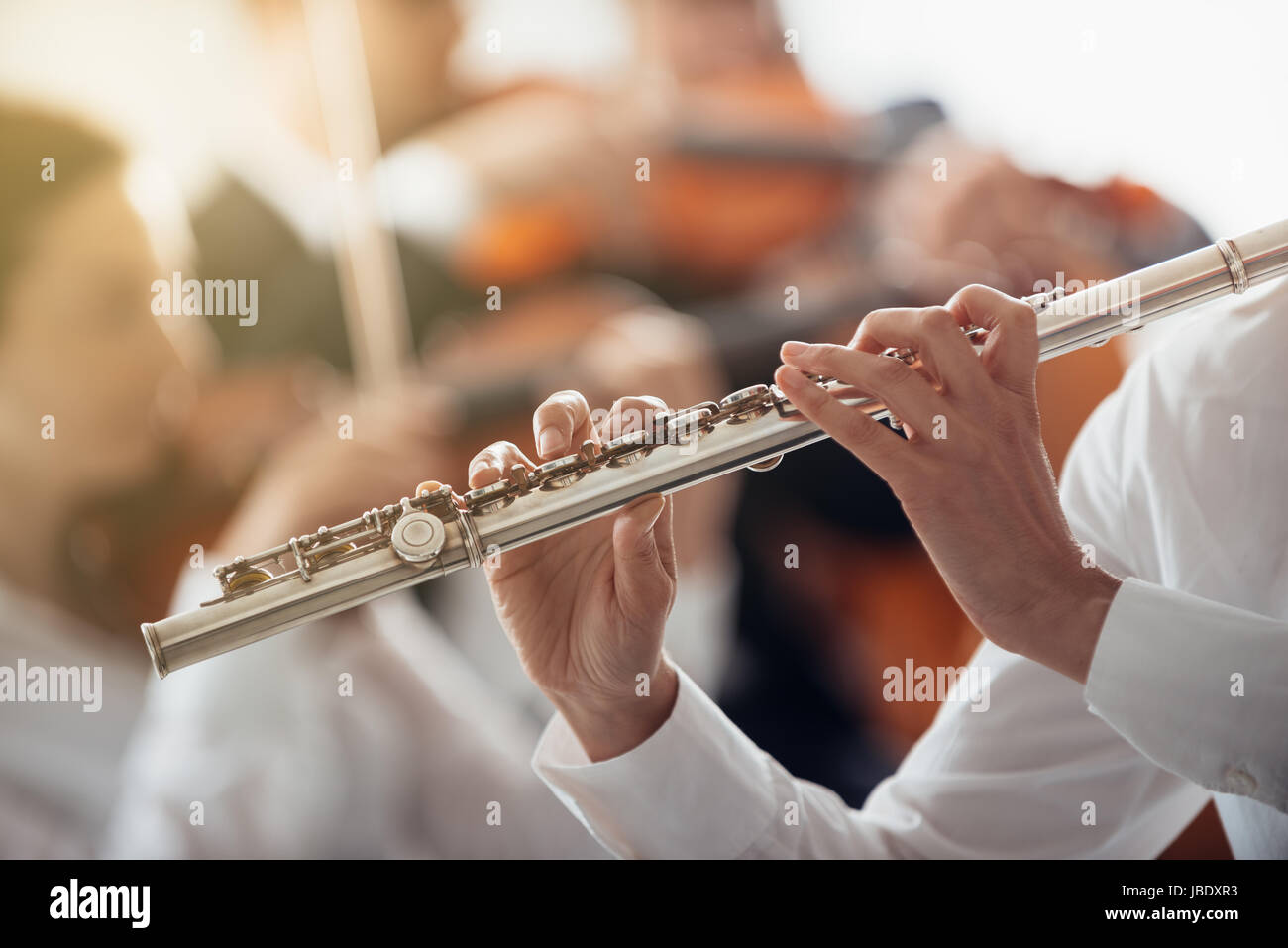 Professional female flute player performing with classical music ...