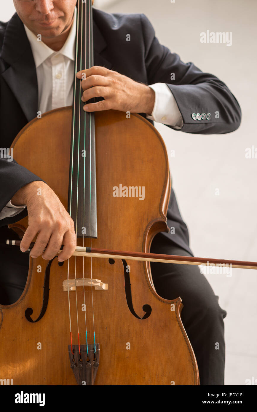 Professional male cellist playing his cello, classical music solo ...