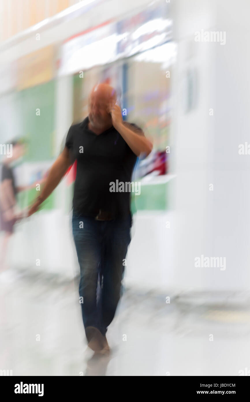 Man walking while talking on the mobile phone Stock Photo - Alamy
