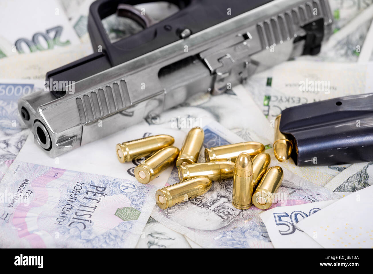 detail of gun with bullet on czech banknotes background Stock Photo - Alamy