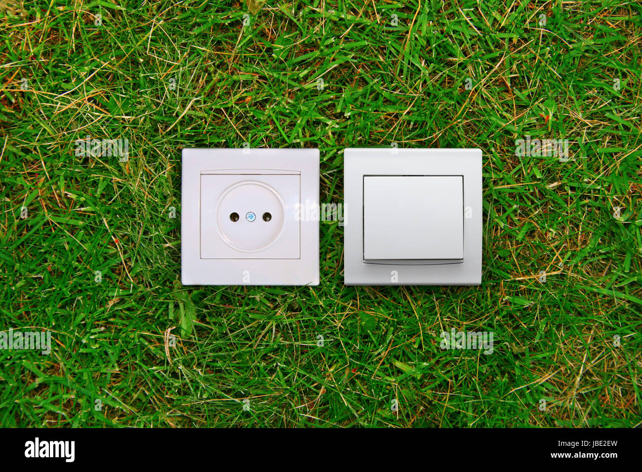 green energy concept: electric outlet and light switch on a grass Stock ...
