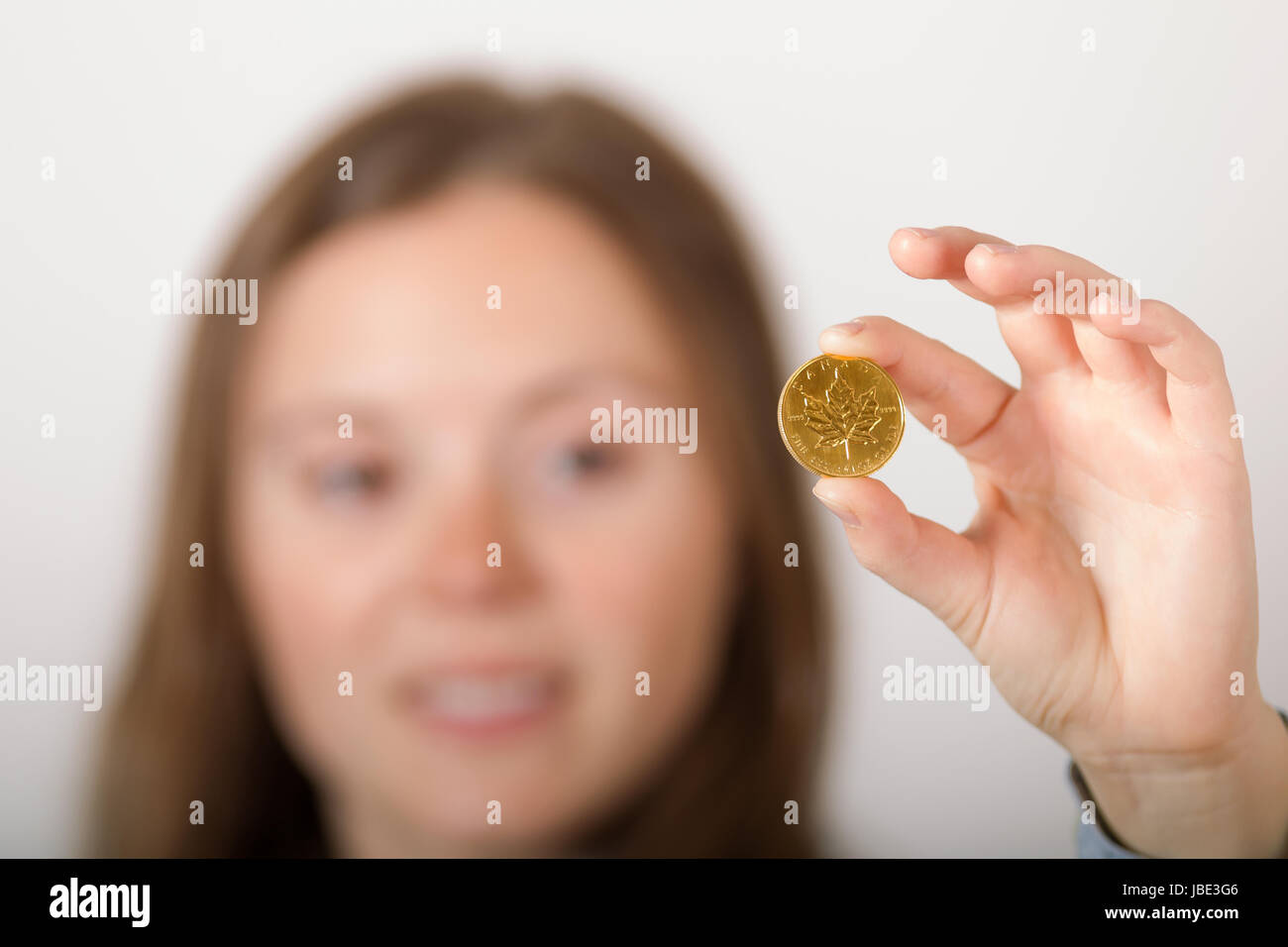 young woman with gold coin Stock Photo - Alamy