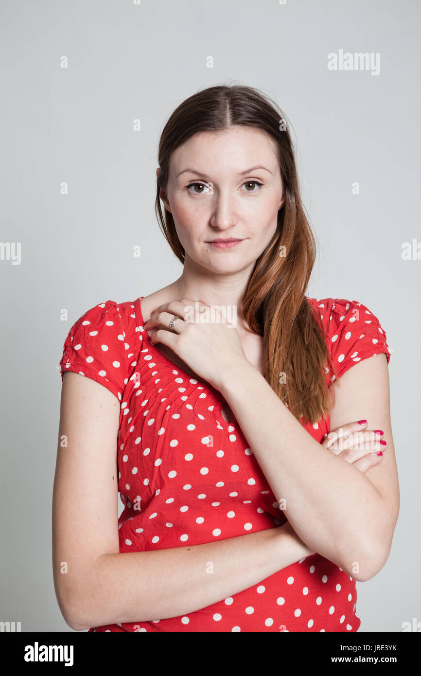 Studio portrait of relaxed and thoughtful looking attractive woman ...