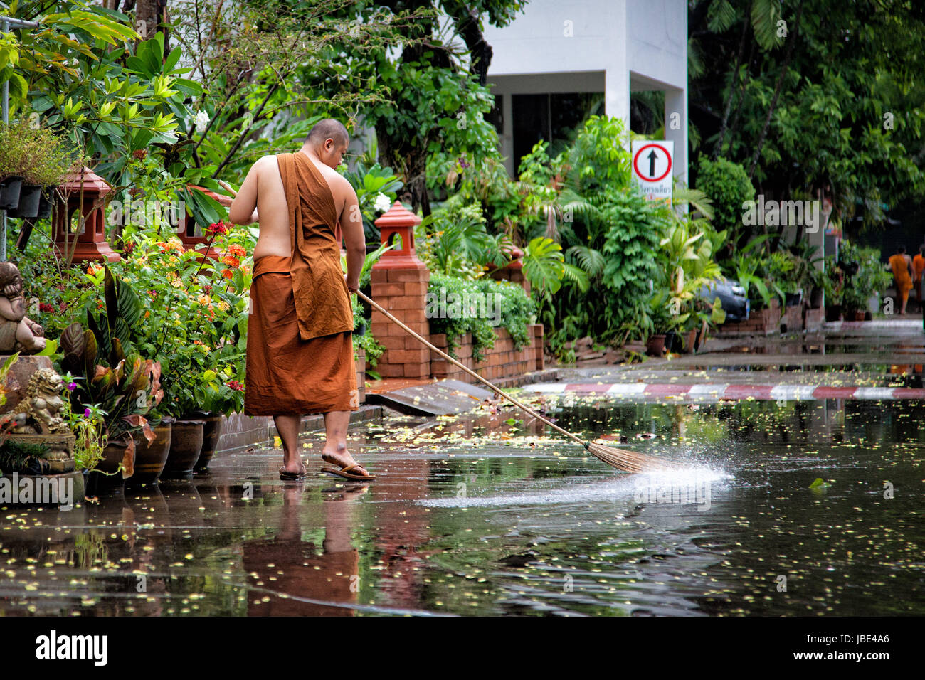 monk cleaning up the water after the rain Stock Photo - Alamy