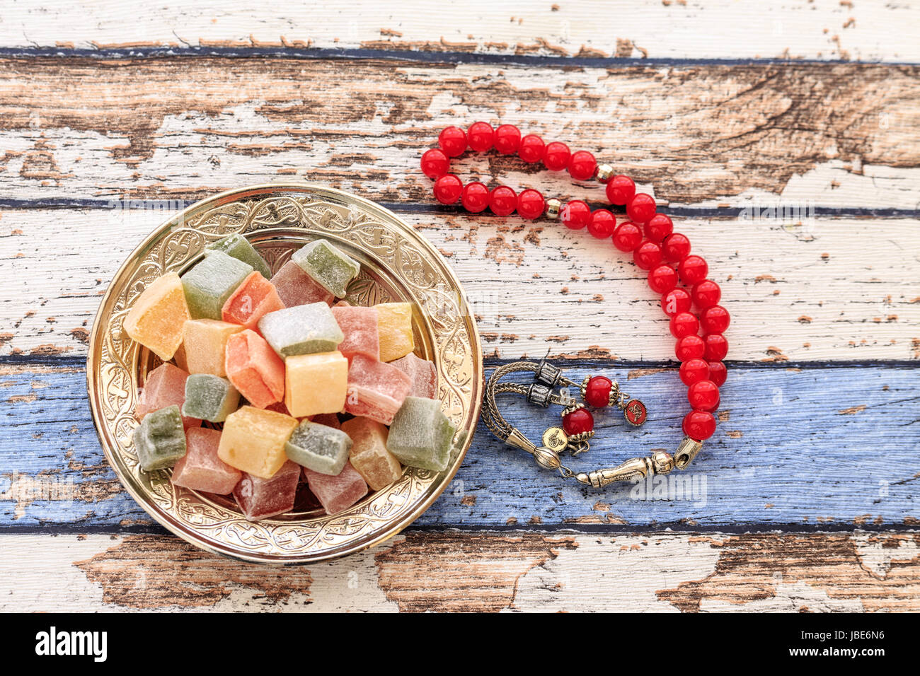 Turkish delights in plate with red rosary on vintage table top view ...