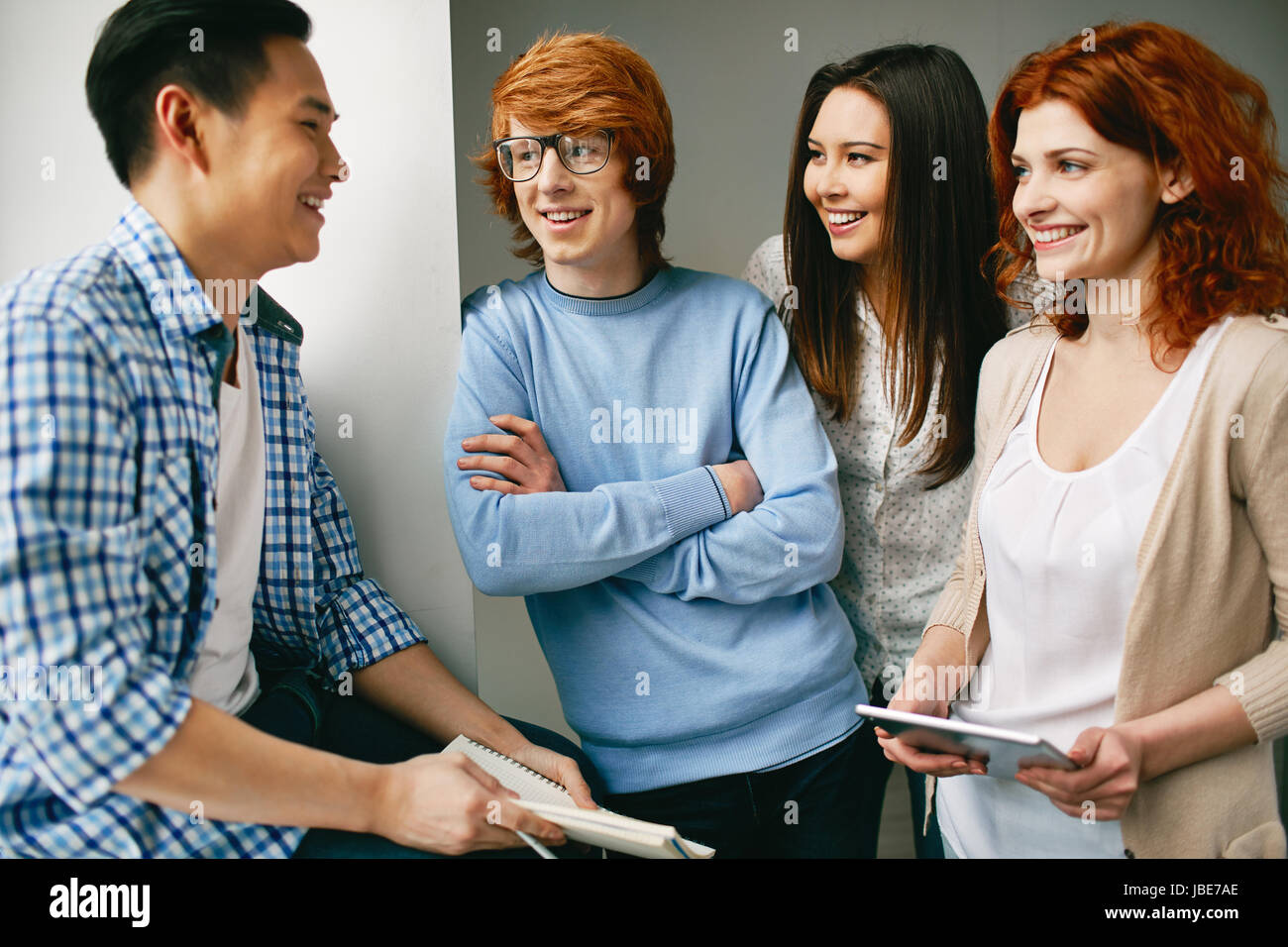 Company of smart groupmates talking in college Stock Photo - Alamy