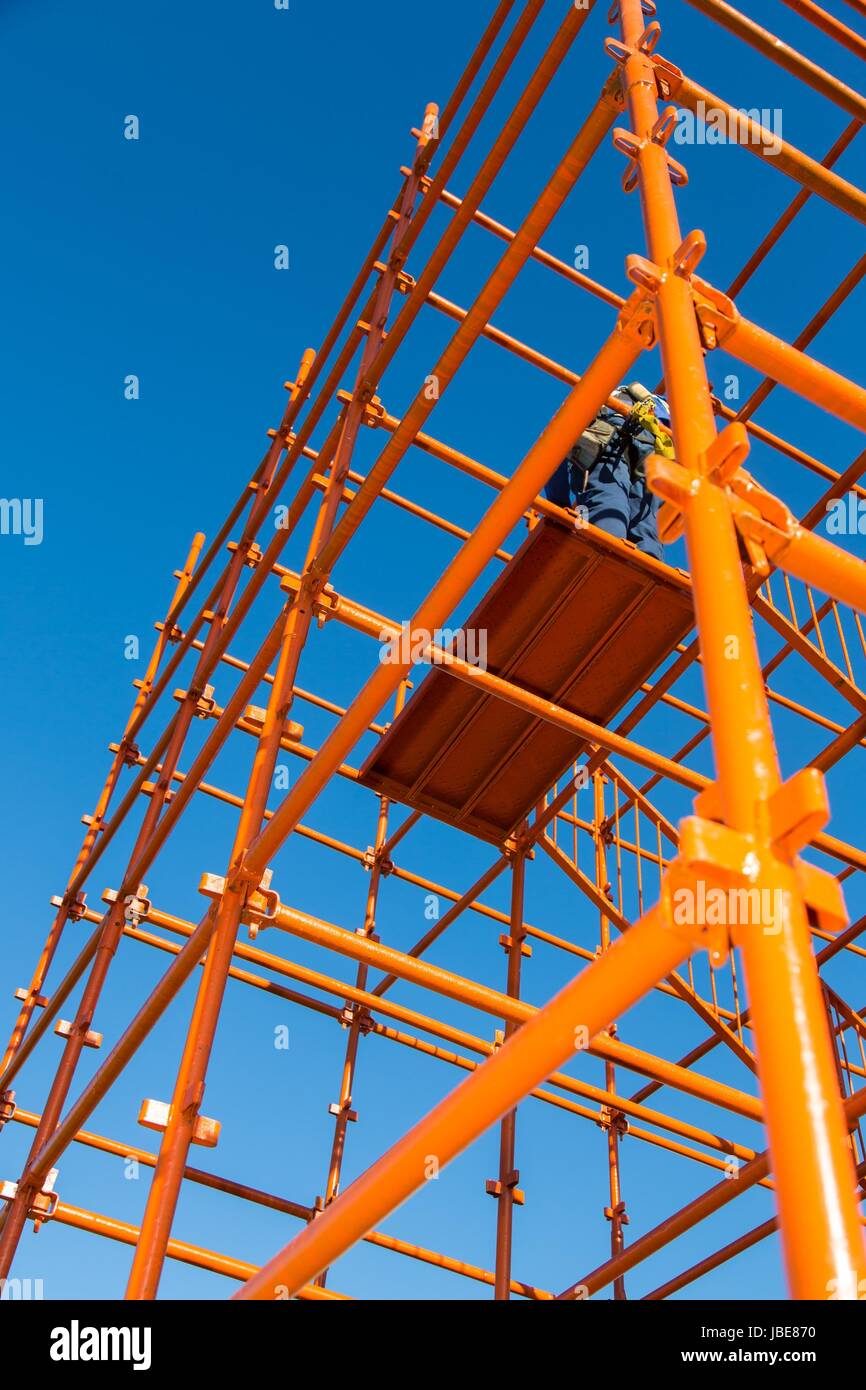 Bright orange scaffolding pipes against a blue sky Stock Photo - Alamy