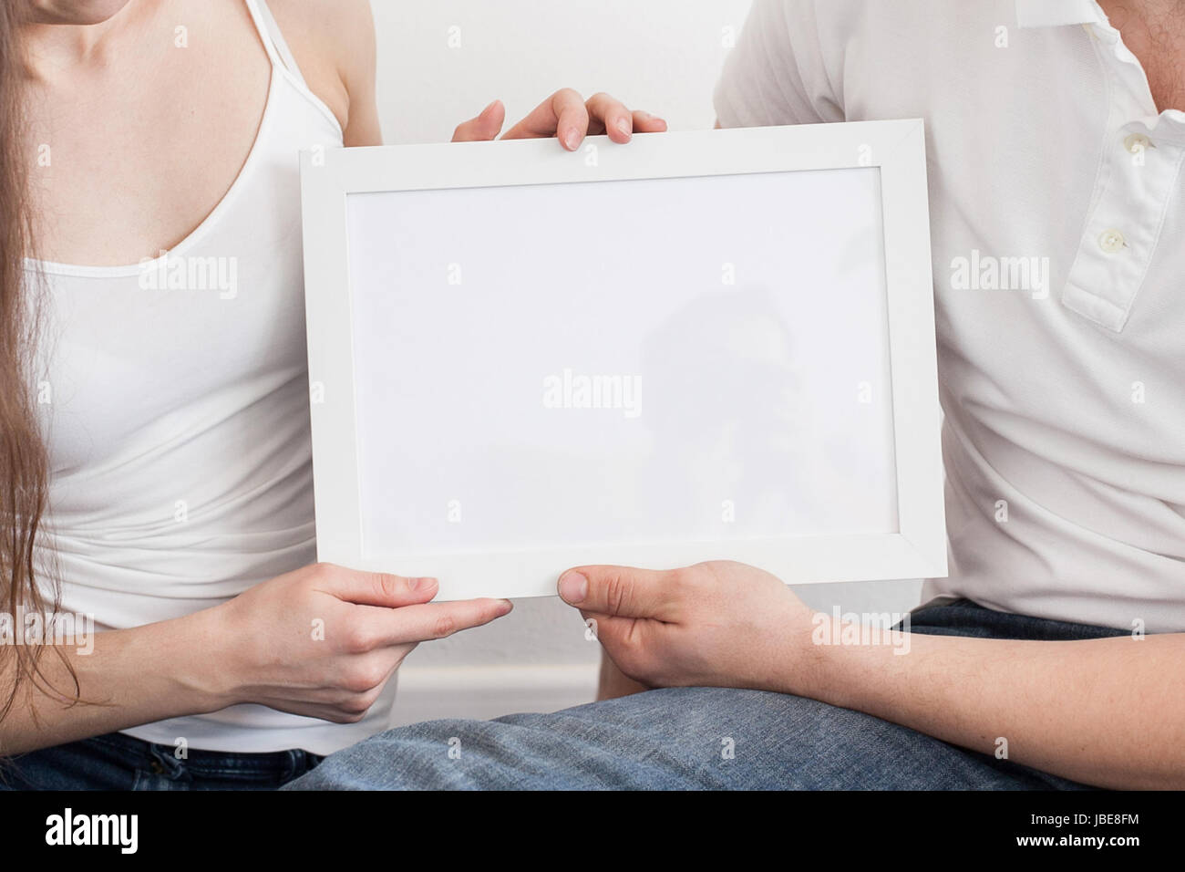 Hands of the man and the woman hold a frame with a clean sheet Stock ...