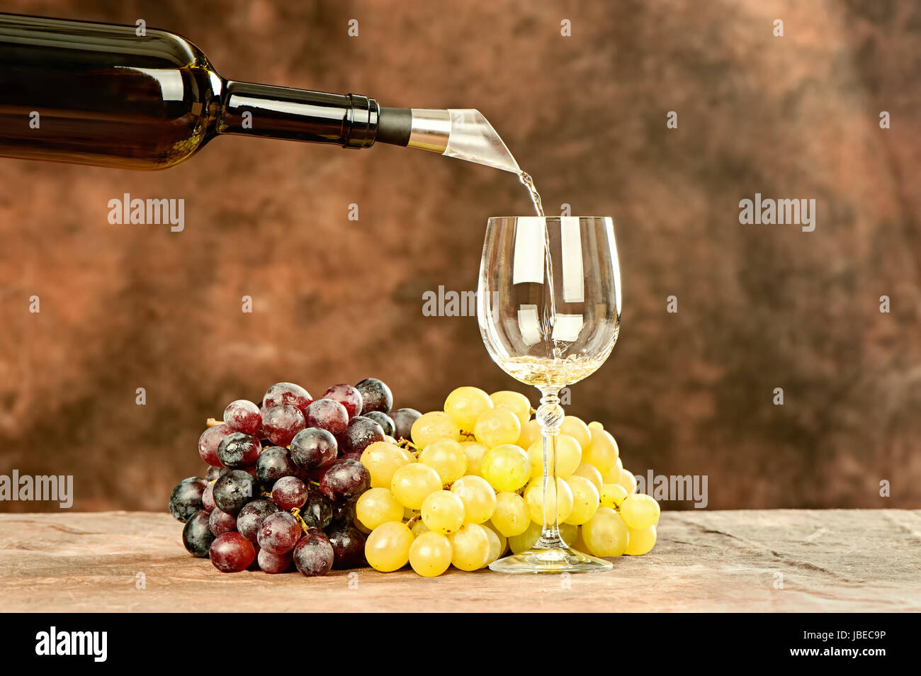 pour wine from bottle in shiny wine cup near grape Stock Photo - Alamy