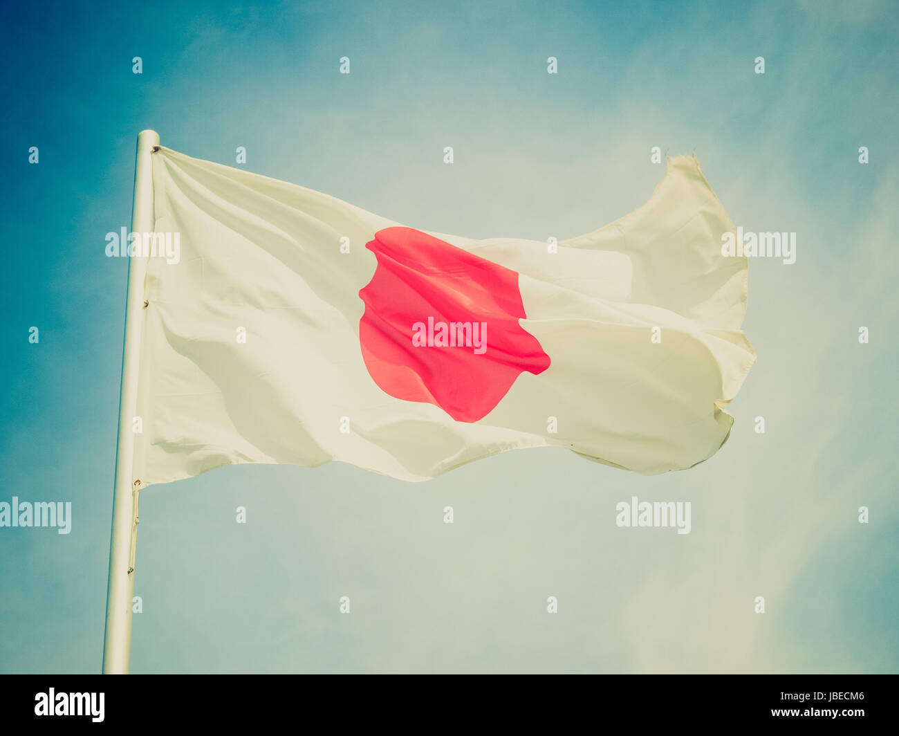 Vintage retro looking Flag of Japan over a blue sky Stock Photo - Alamy
