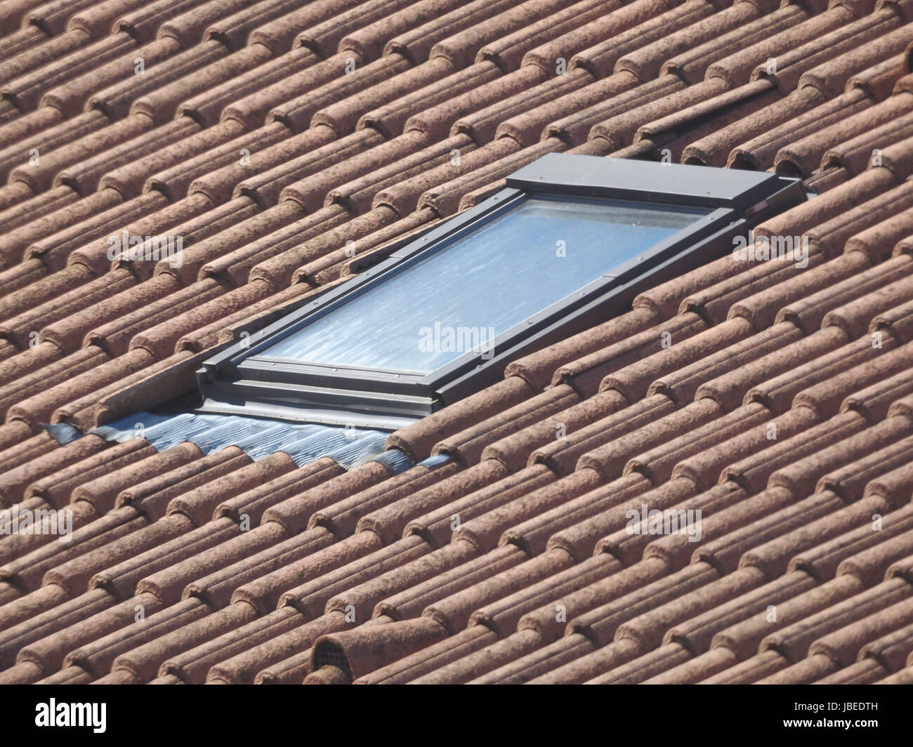 Detail of red roof tiles and roof window Stock Photo - Alamy