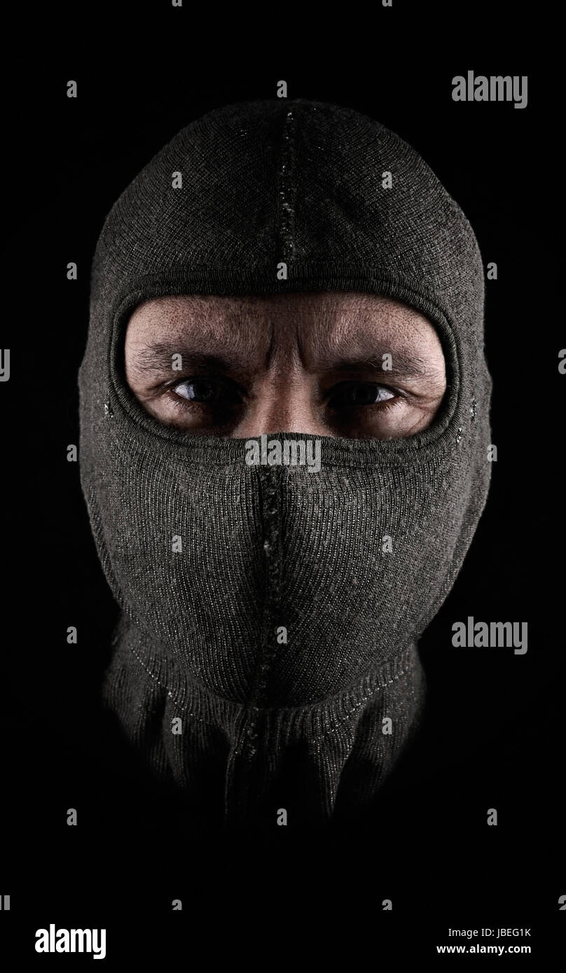 Masked man on a dark background Stock Photo - Alamy