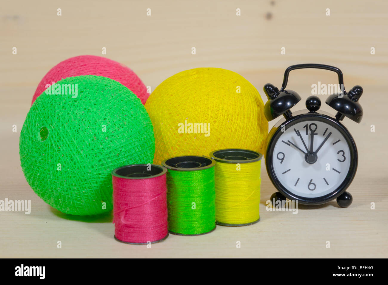 Clock, multi-colored yarn for various fabrics, worn cloth on wooden ...