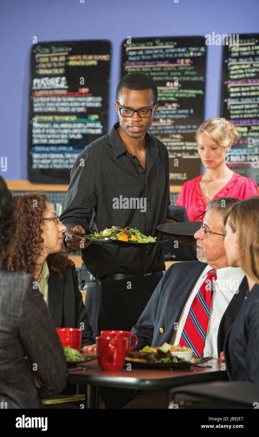 Young barista serving diverse group of customers Stock Photo - Alamy
