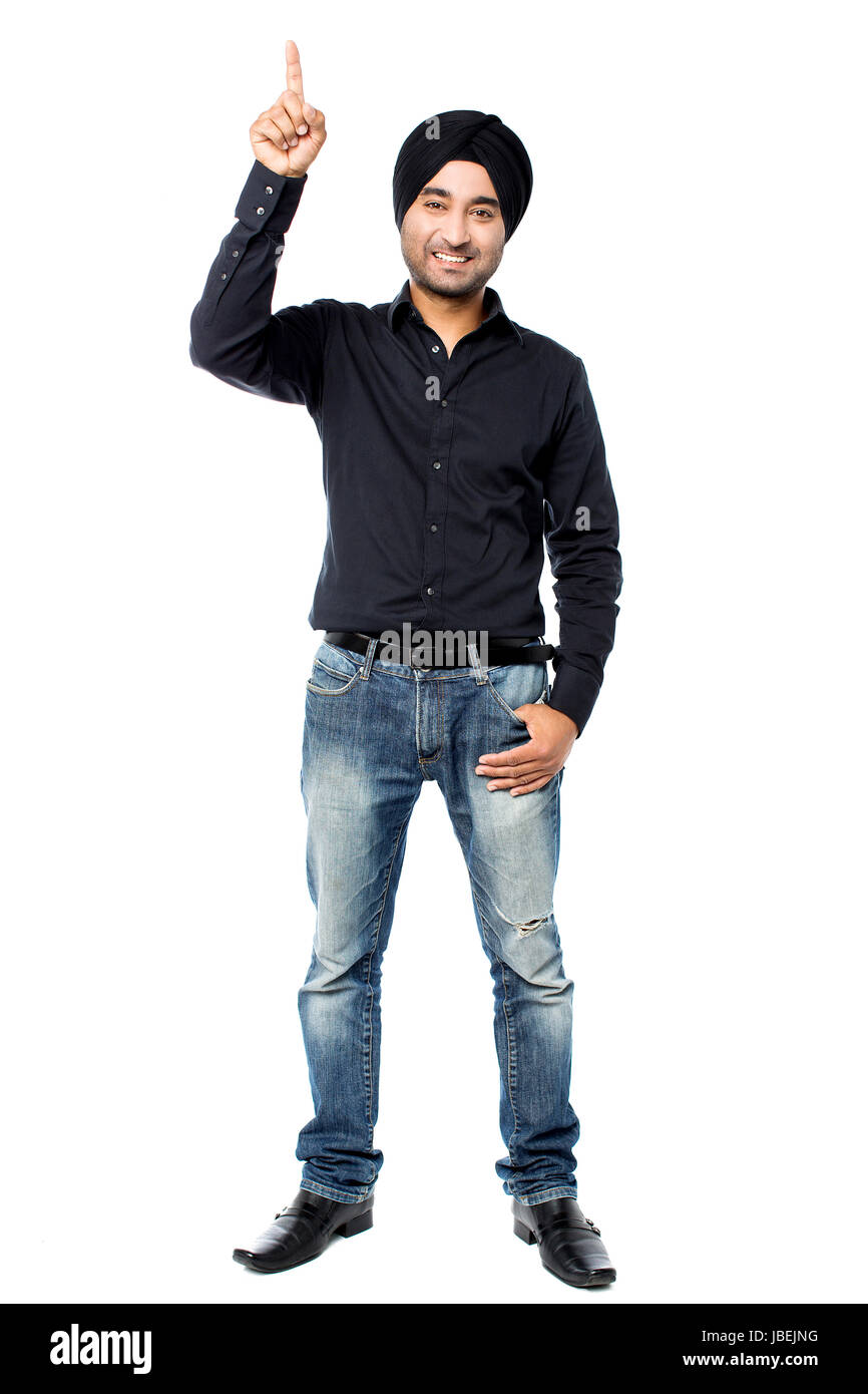 Handsome young Indian guy pointing upwards Stock Photo - Alamy