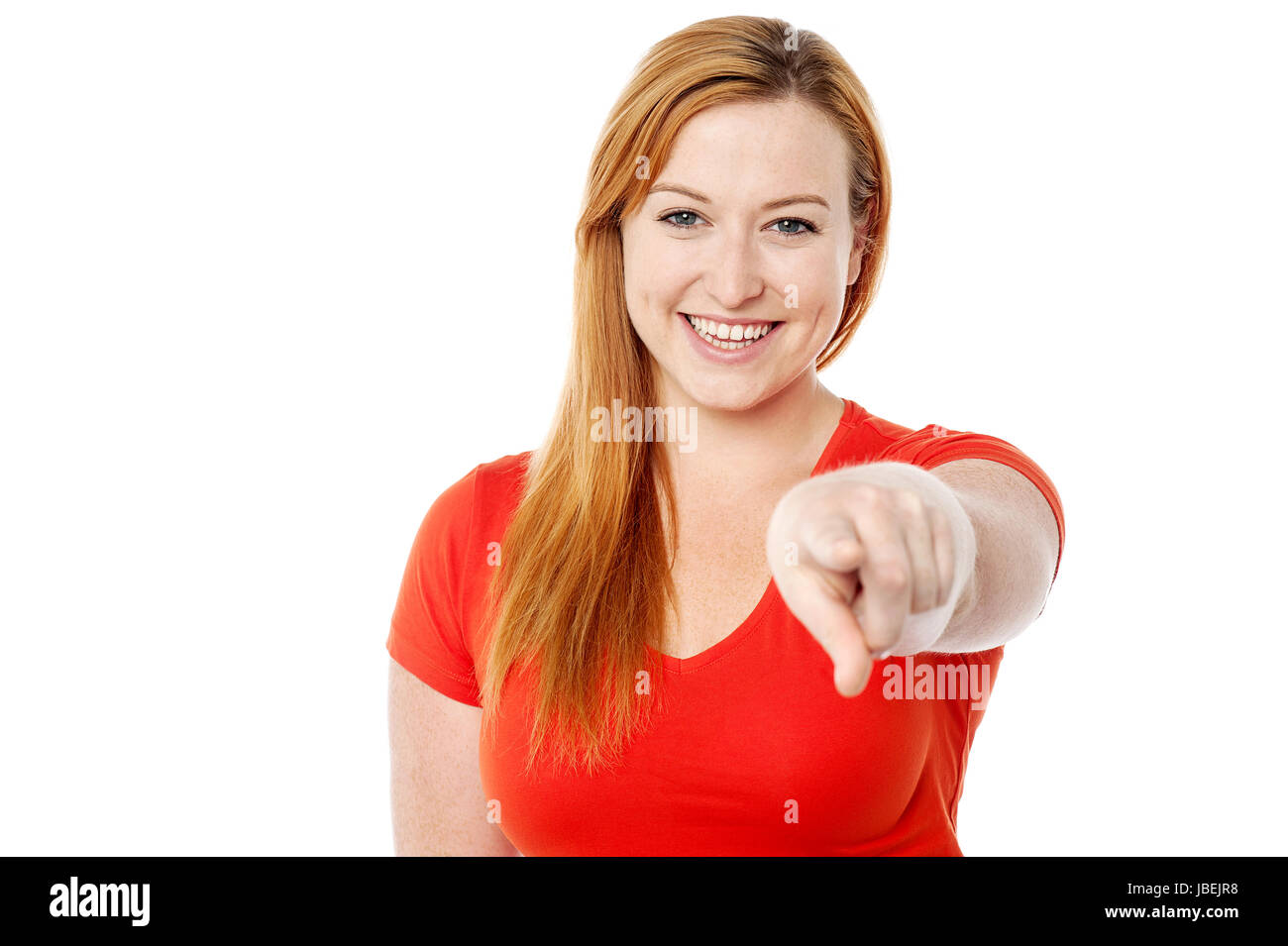Smiling young girl pointing towards camera Stock Photo - Alamy