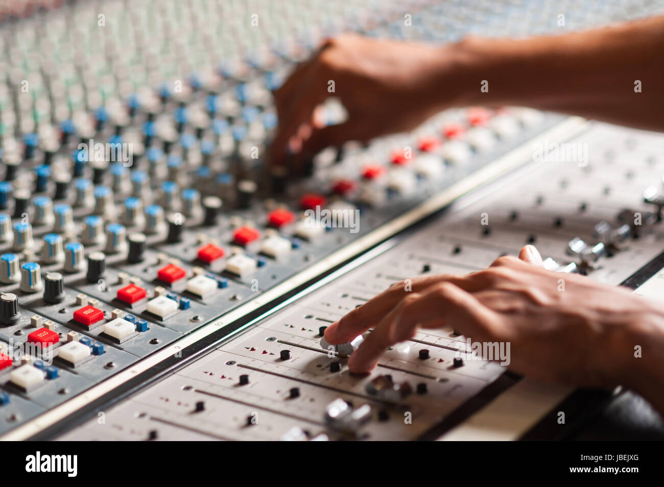 An expert adjusting audio mixing console Stock Photo - Alamy