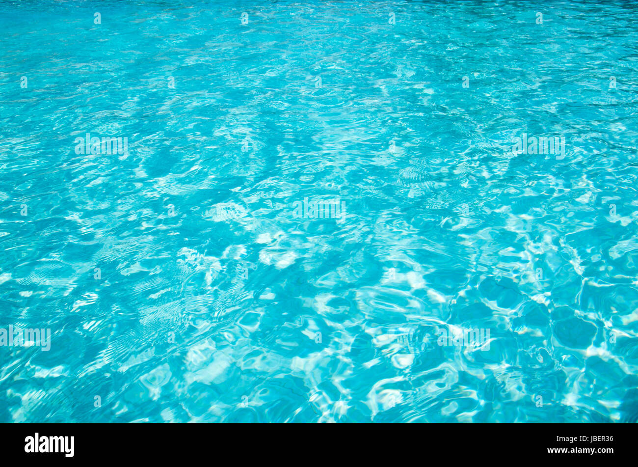 Blue pool water with sun reflections Stock Photo - Alamy