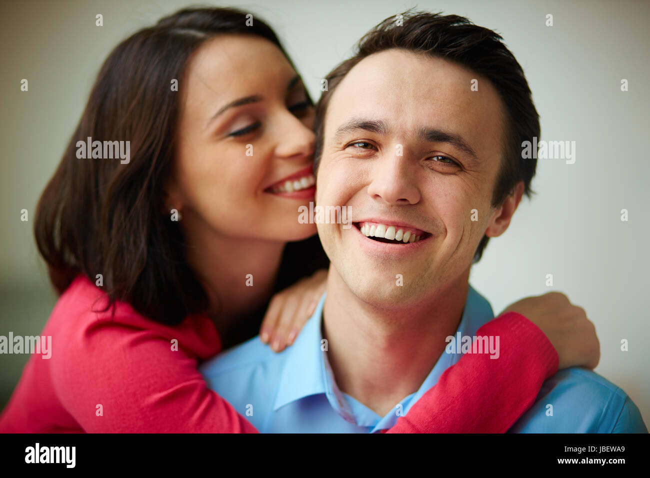 Portrait of amorous young woman embracing her happy husband Stock Photo ...