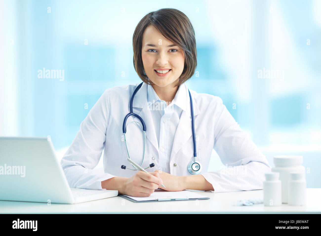 Portrait of a smiling physician working in her office Stock Photo - Alamy