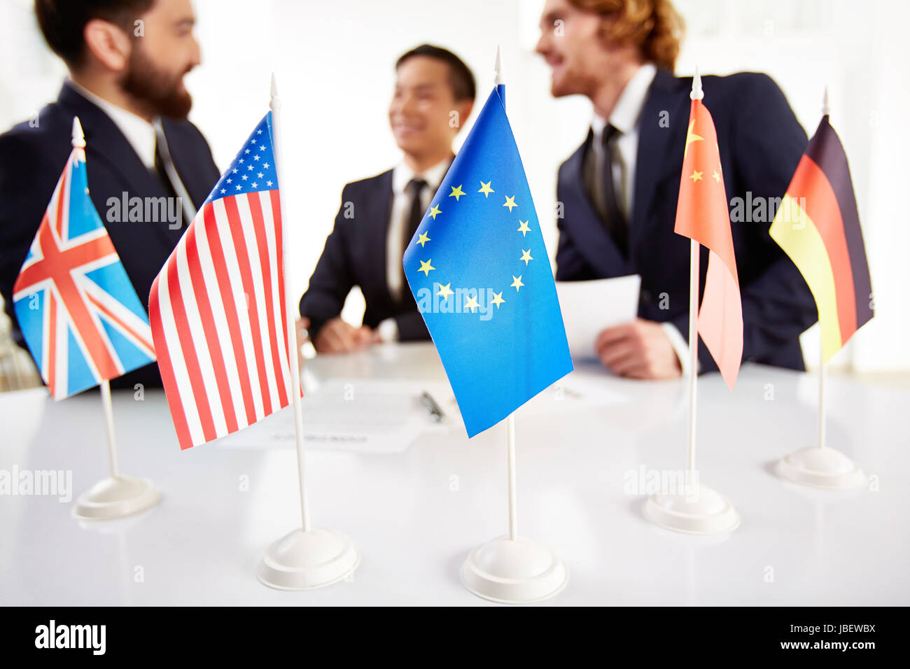 Image of several flags of different countries on workplace with three ...