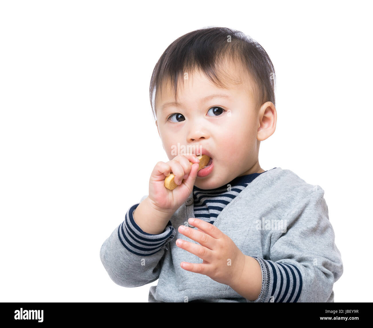 Asian baby boy eating biscuit Stock Photo - Alamy